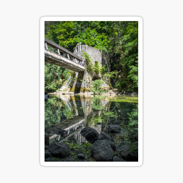"Pedestrian bridge crossing wild river with old mill building" Sticker ...