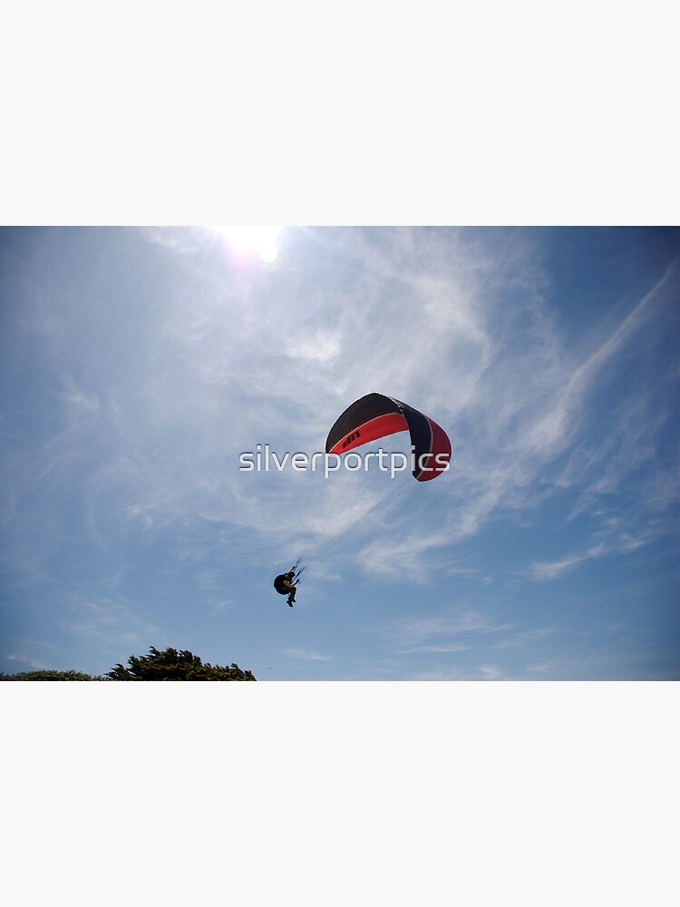 "Parascender, with the word 'Up" on red and black canopy, in mid flight ...