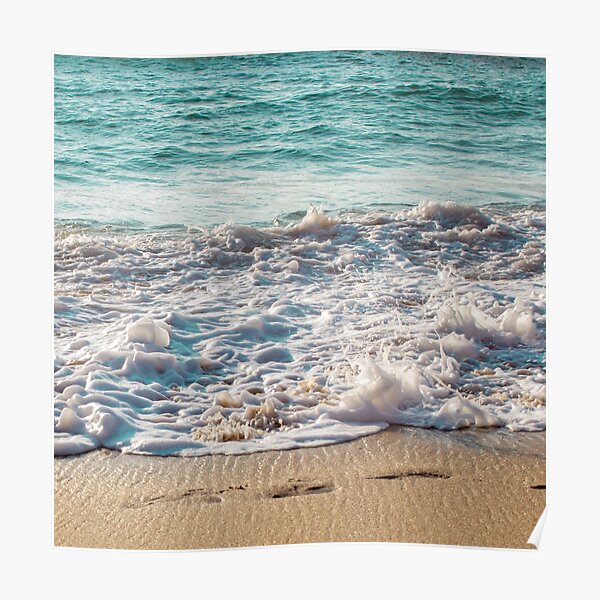 "Blue ocean water, splashing waves on beach sand with footprints ...
