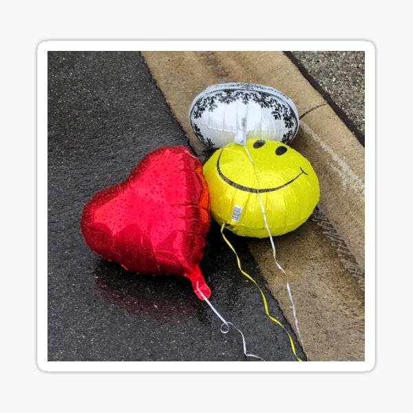 "Three sad helium balloons lay deflated on the wet street on a rainy ...