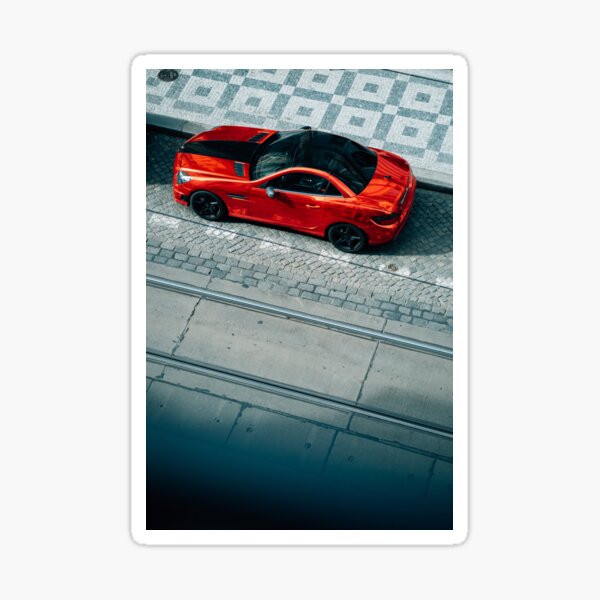 "Red car with black roof parked on the side of a road" Sticker by ...