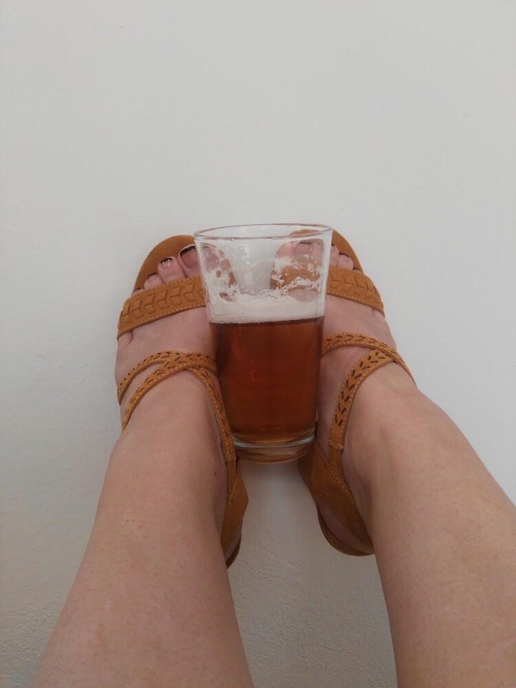 "A glass with a beer between the feet, soles and toes, foot models ...